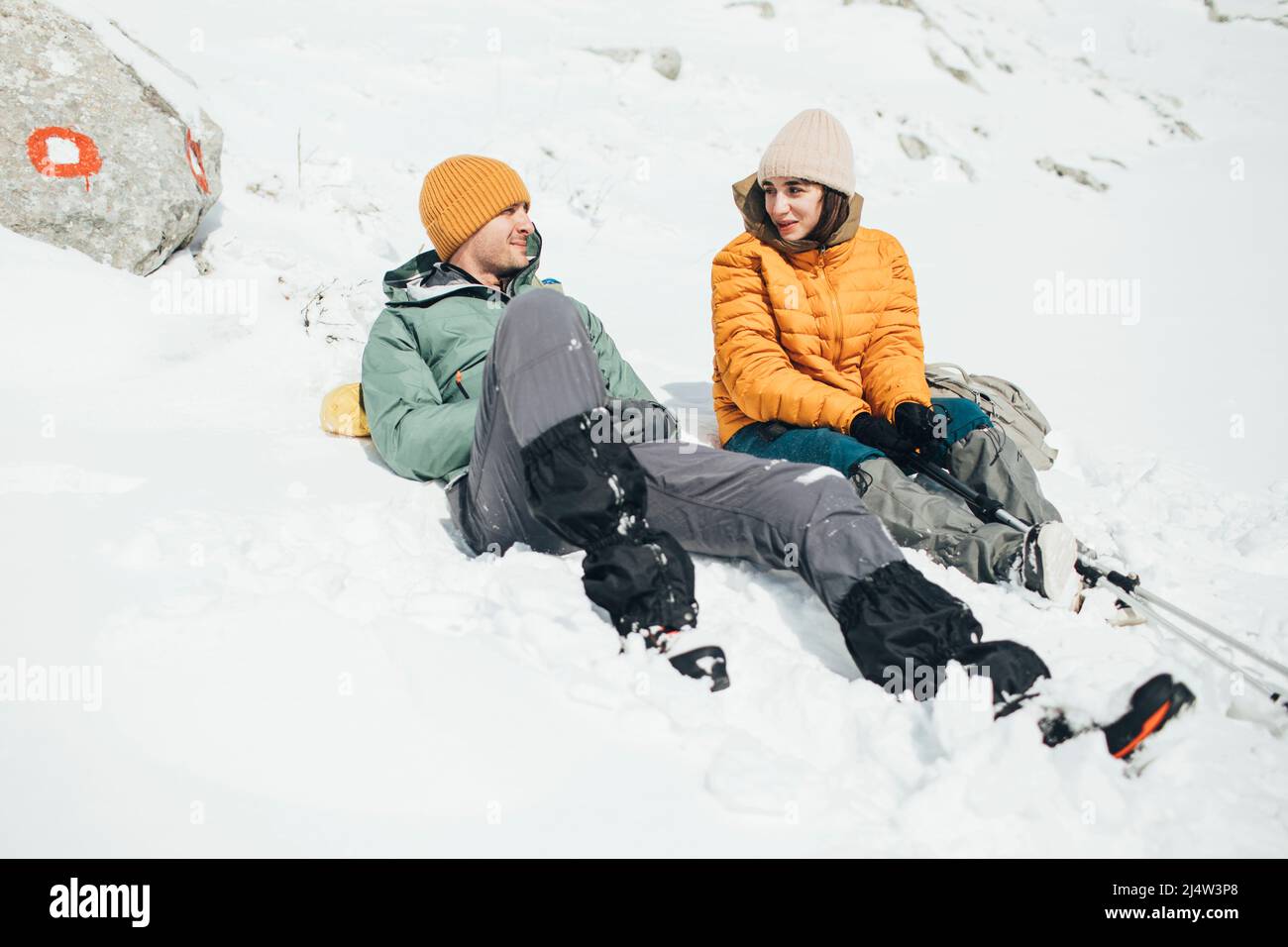 Two hikers ascending over snowy mountain ridge Stock Photo - Alamy