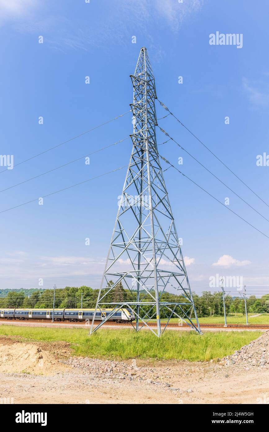 Electric power distribution by a railroad with a train Stock Photo - Alamy