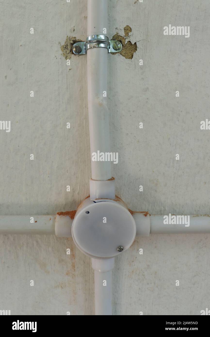 plastic pipe and four angle side pipe attached on the wall Stock Photo ...