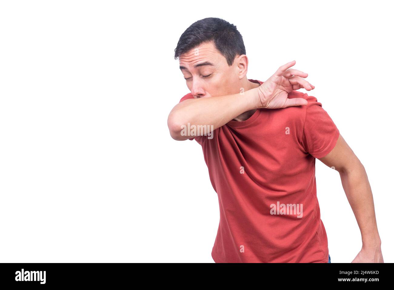 Man sneezing in elbow in light studio Stock Photo - Alamy