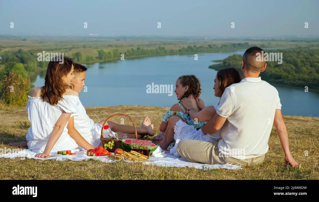 Large family enjoys river view at festive picnic in summer Stock Photo ...