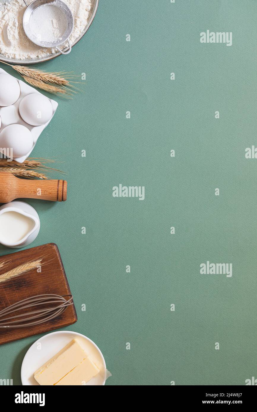 Frame of food ingredients for baking on a green pastel background ...