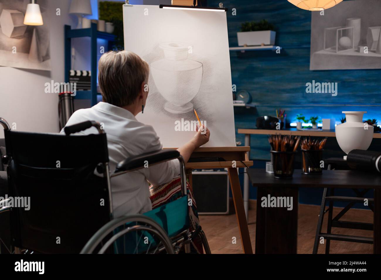 Portrait of elderly artist living with disability drawing still life ...
