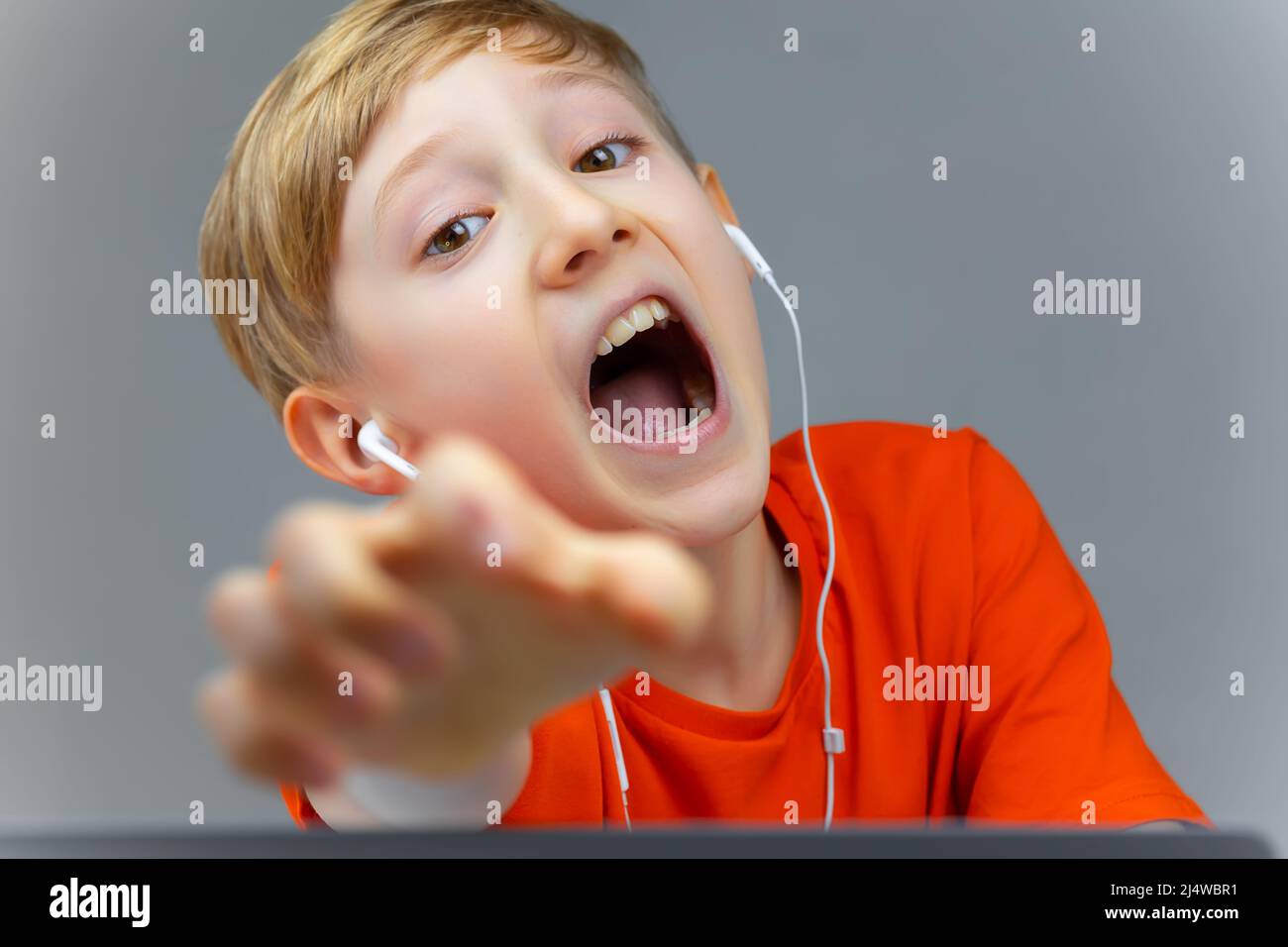 the boy behind the laptop screams loudly and reaches for the camera ...