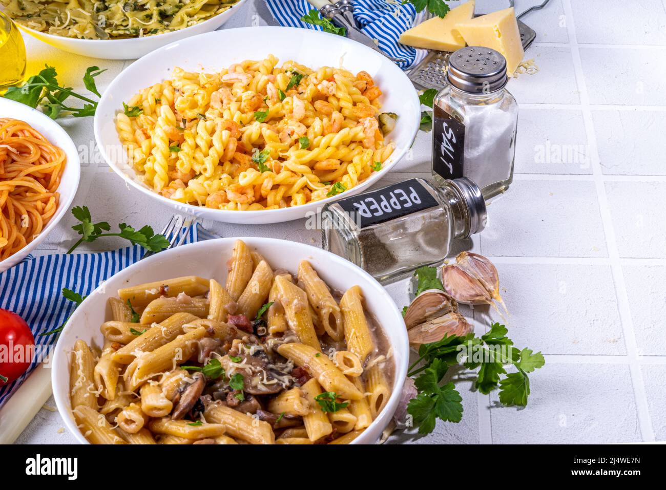 Set of pasta with different sauces on white tiled background. Spaghetti ...