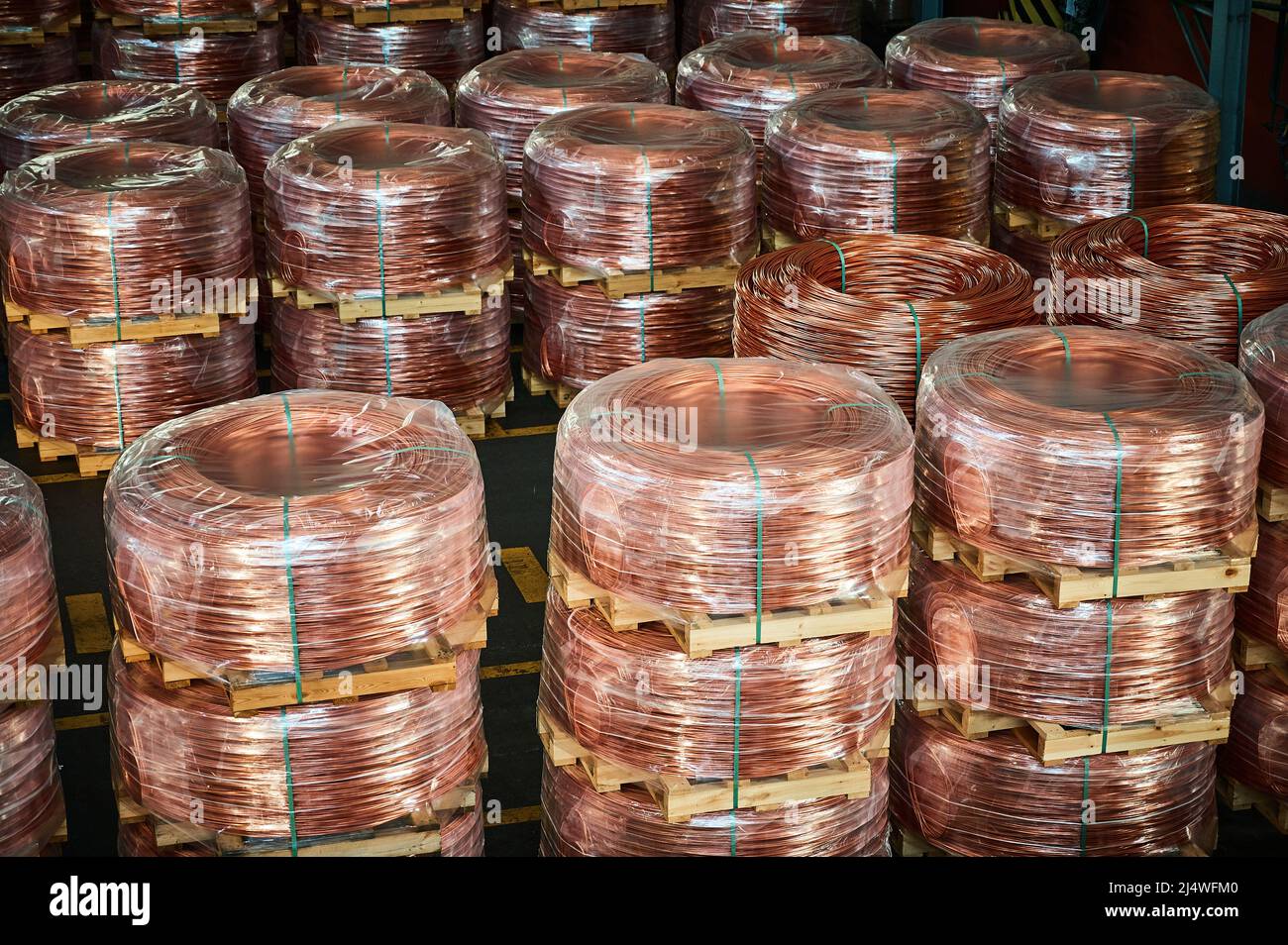 Rows of wrapped copper cable coils in light plant warehouse Stock Photo ...