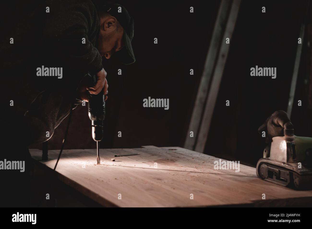 The carpenter works with a hand drill. man drilling a board Stock Photo ...