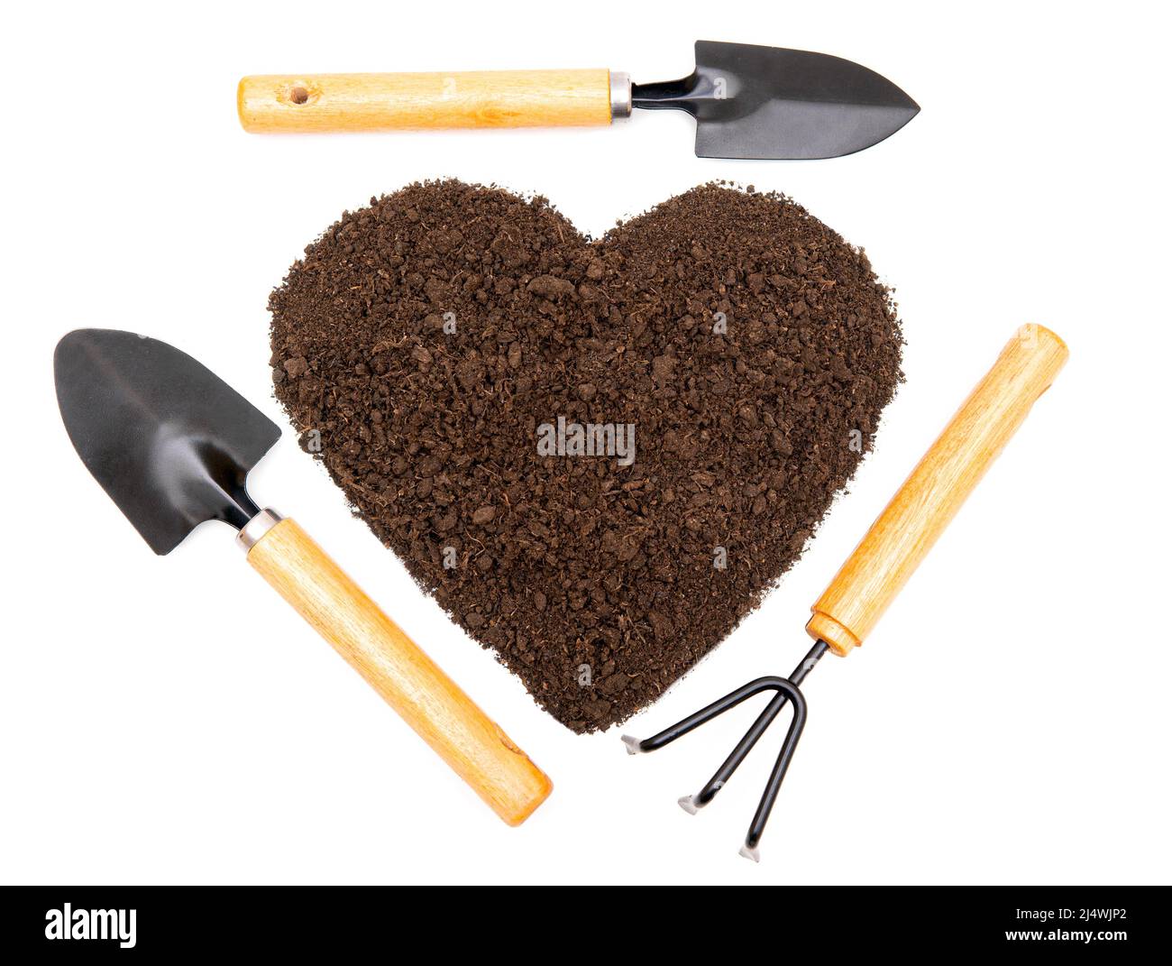 Various garden hand tools framing a heart-shaped pile of soil isolated ...