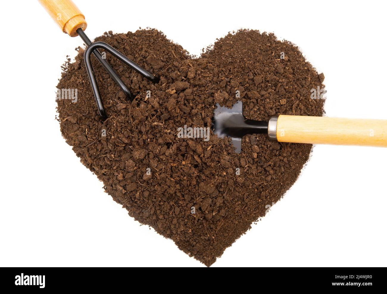 Hand transplanter and cultivator in a heart shaped pile of soil ...