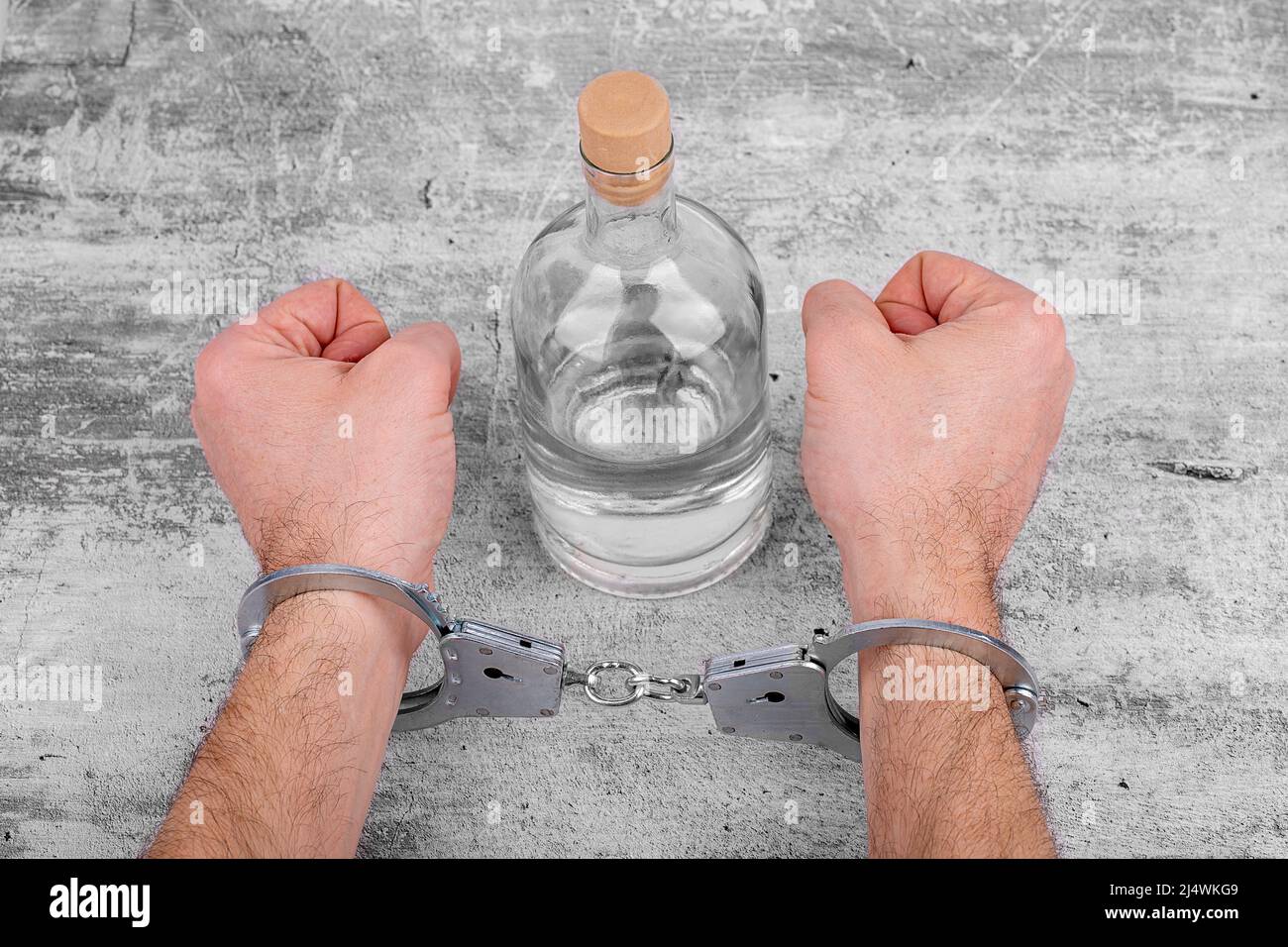 The concept of male alcohol addiction. Male hands in handcuffs next to ...