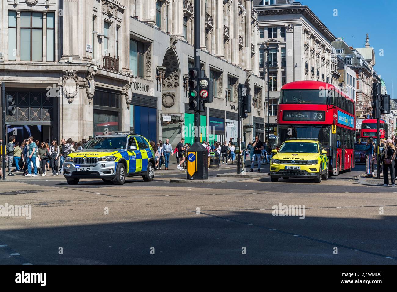 Police and ambulance cars and buses and Shoppers on Oxford Street, a ...