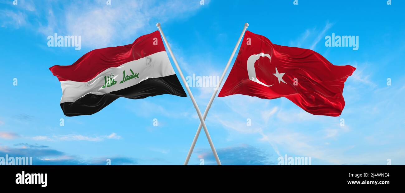 two crossed flags Iraq and Turkey waving in wind at cloudy sky. Concept ...