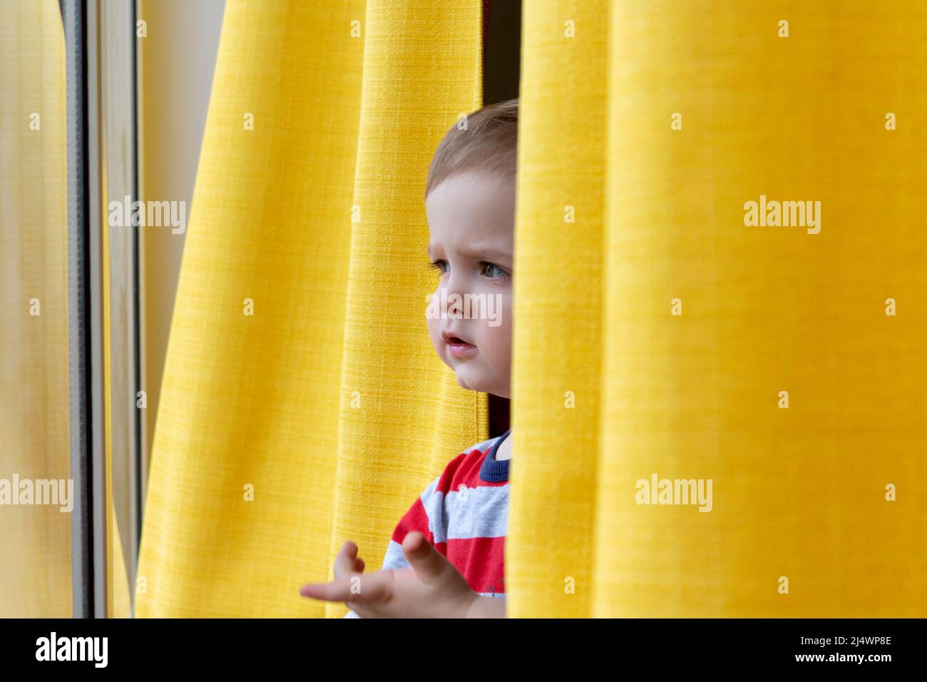 Little boy looking out the window. Close-up Stock Photo - Alamy