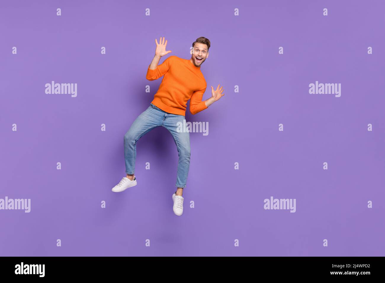 Full length photo of good mood overjoyed male jumping up wave hands say ...