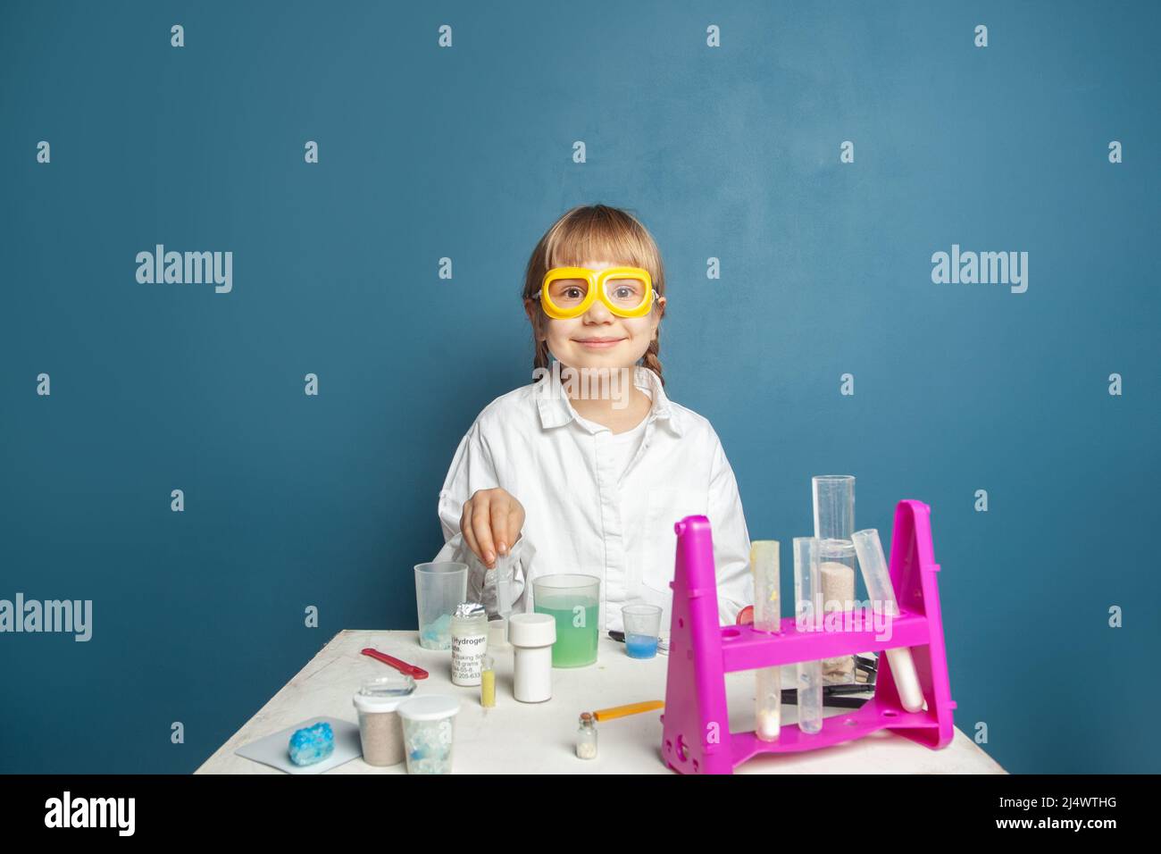 Happy little girl with conical flasks in school classroom Stock Photo ...