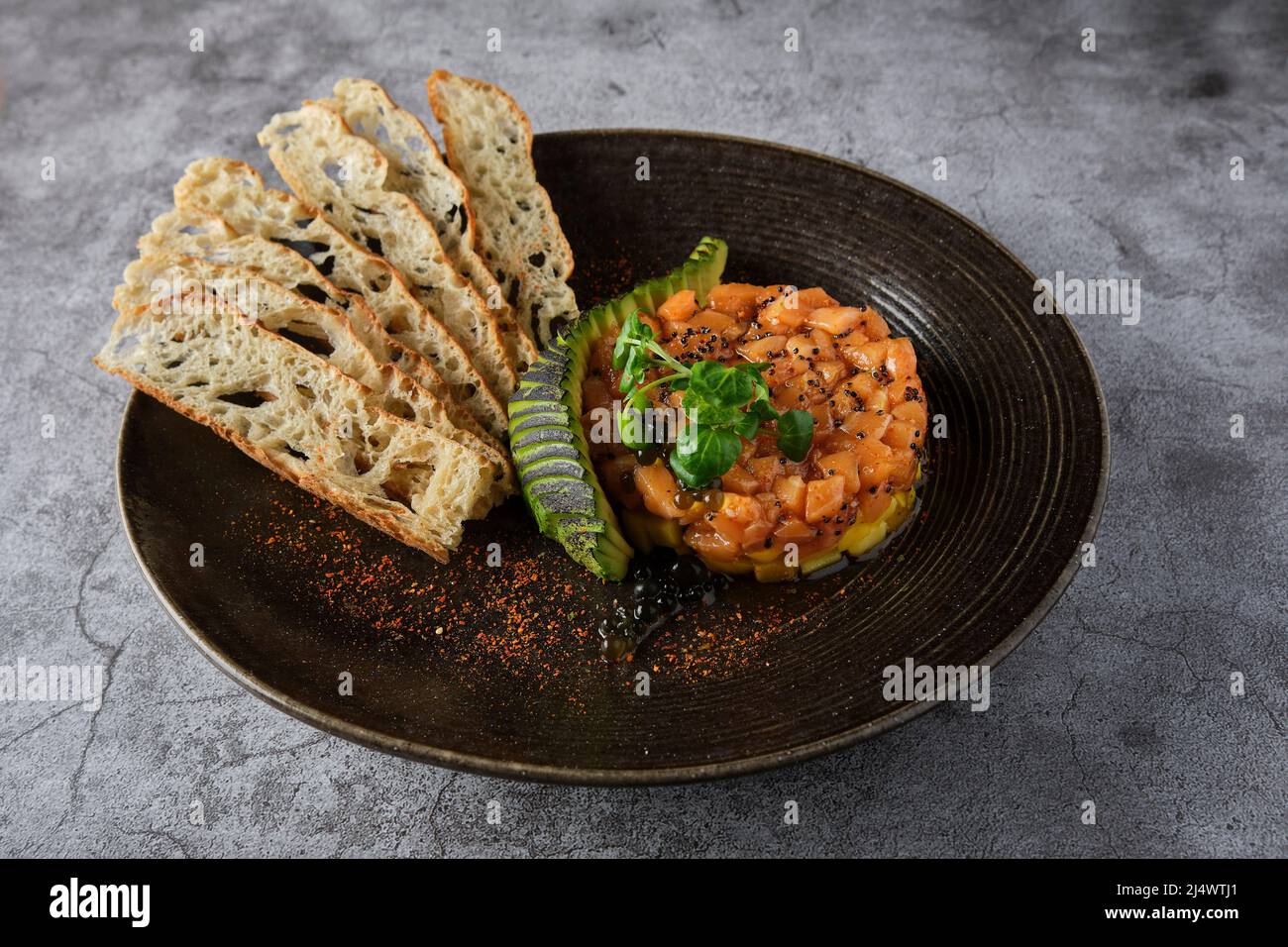 Gourmet fish tartar raw from tuna fillet with hashed avocado, selective ...
