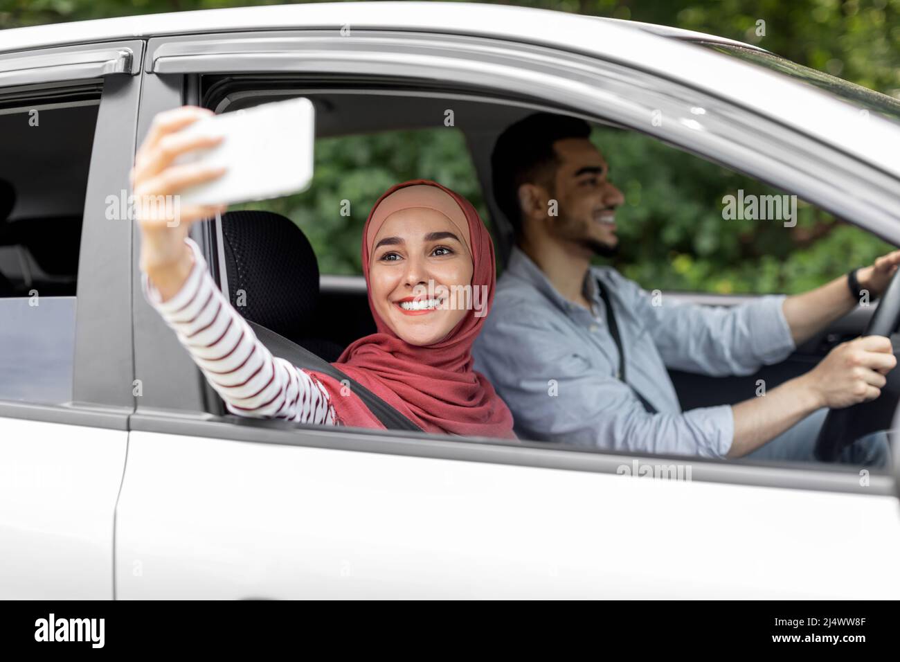 Glad millennial arab woman in hijab takes selfie or livestream on ...