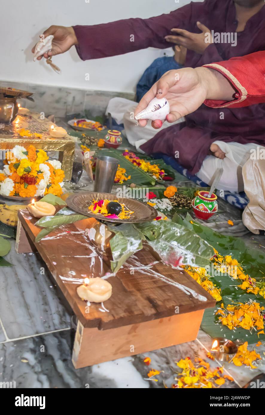 devotee doing religious ritual of holy god with conch shell and blurred ...