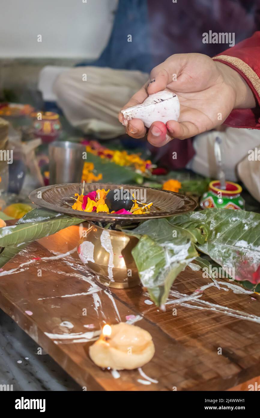 devotee doing religious ritual of holy god with conch shell and blurred ...