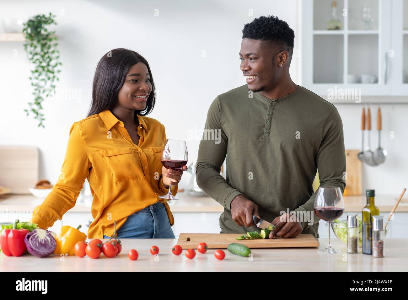 Happy Black Woman Drinking Wine While Her Husband Cooking Salad In ...