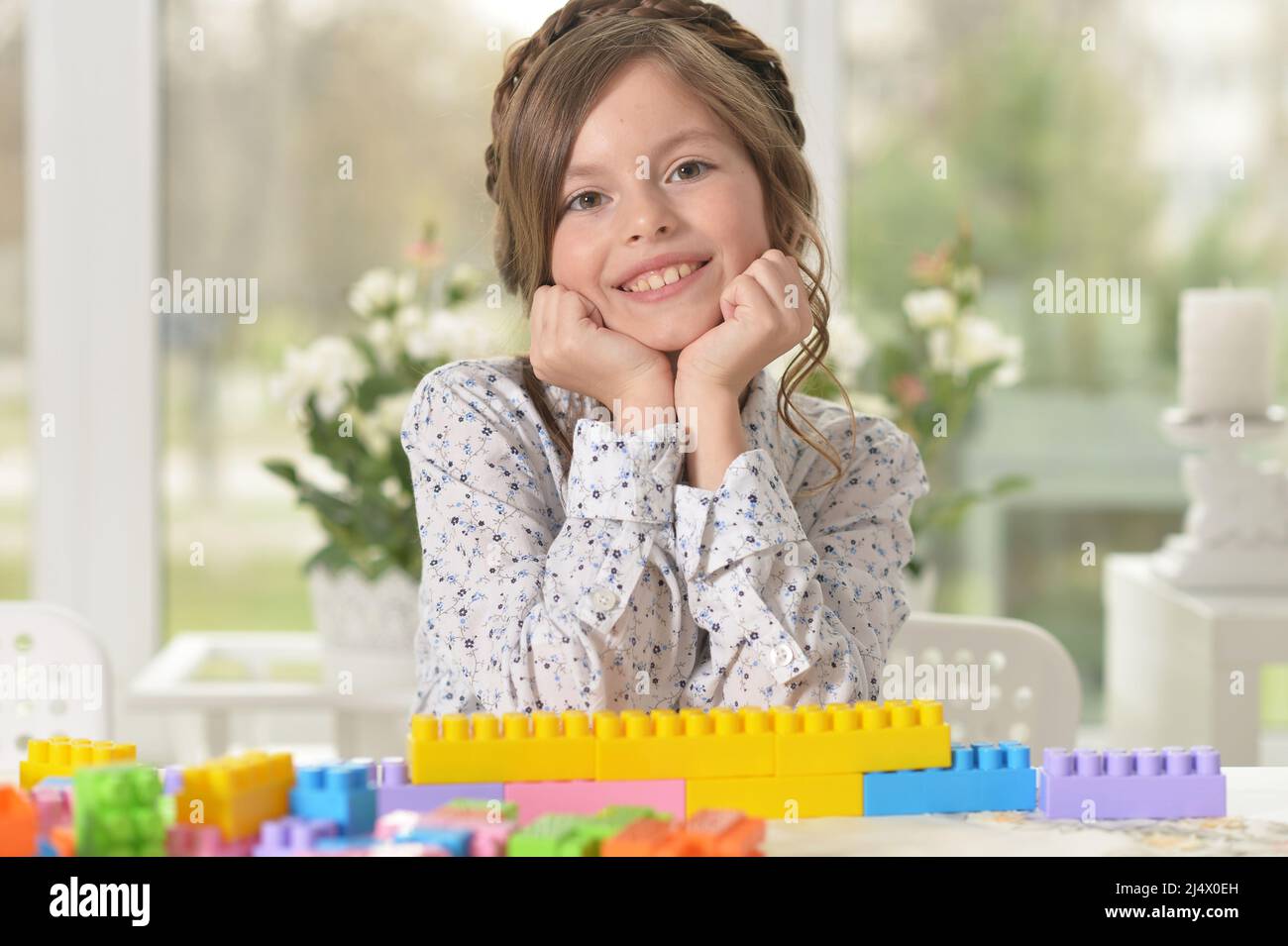Cute little girl with colorful blocks at home Stock Photo - Alamy