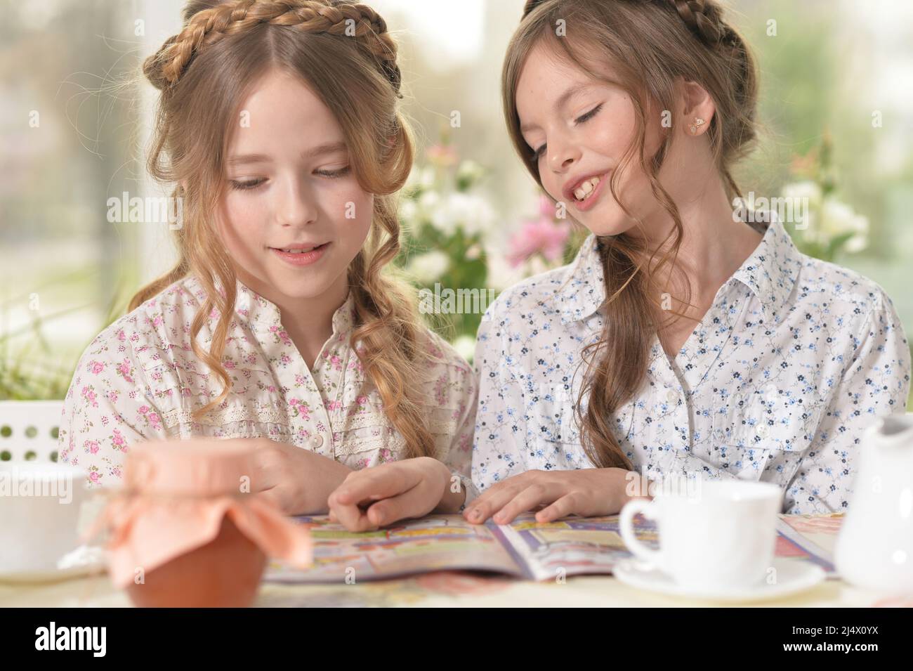 Girls reading magazine, and drinking tea Stock Photo - Alamy