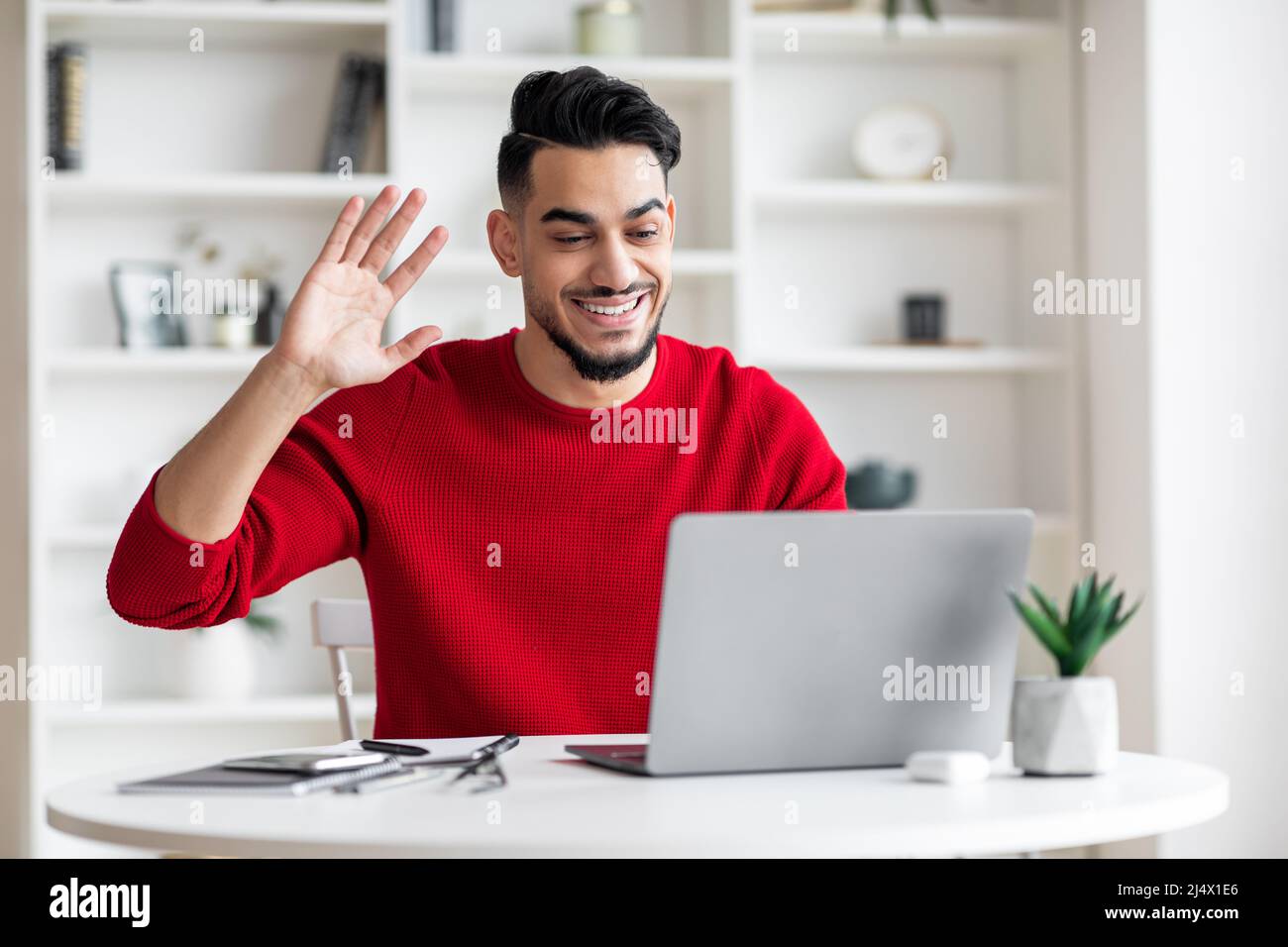 Happy attractive young islamic guy with beard in red clothes waving ...