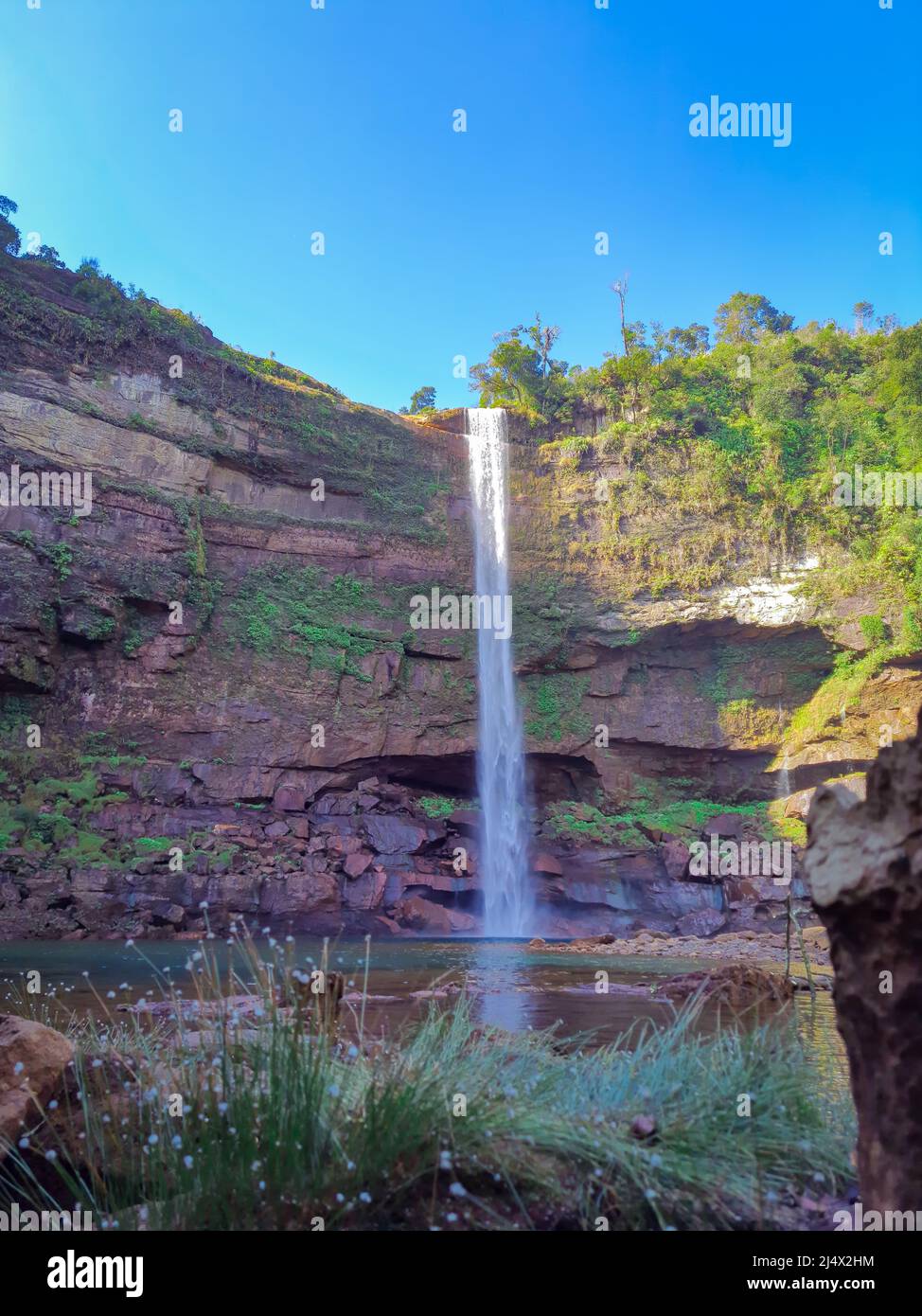 waterfall falling from mountain top with blue sky at morning from low ...