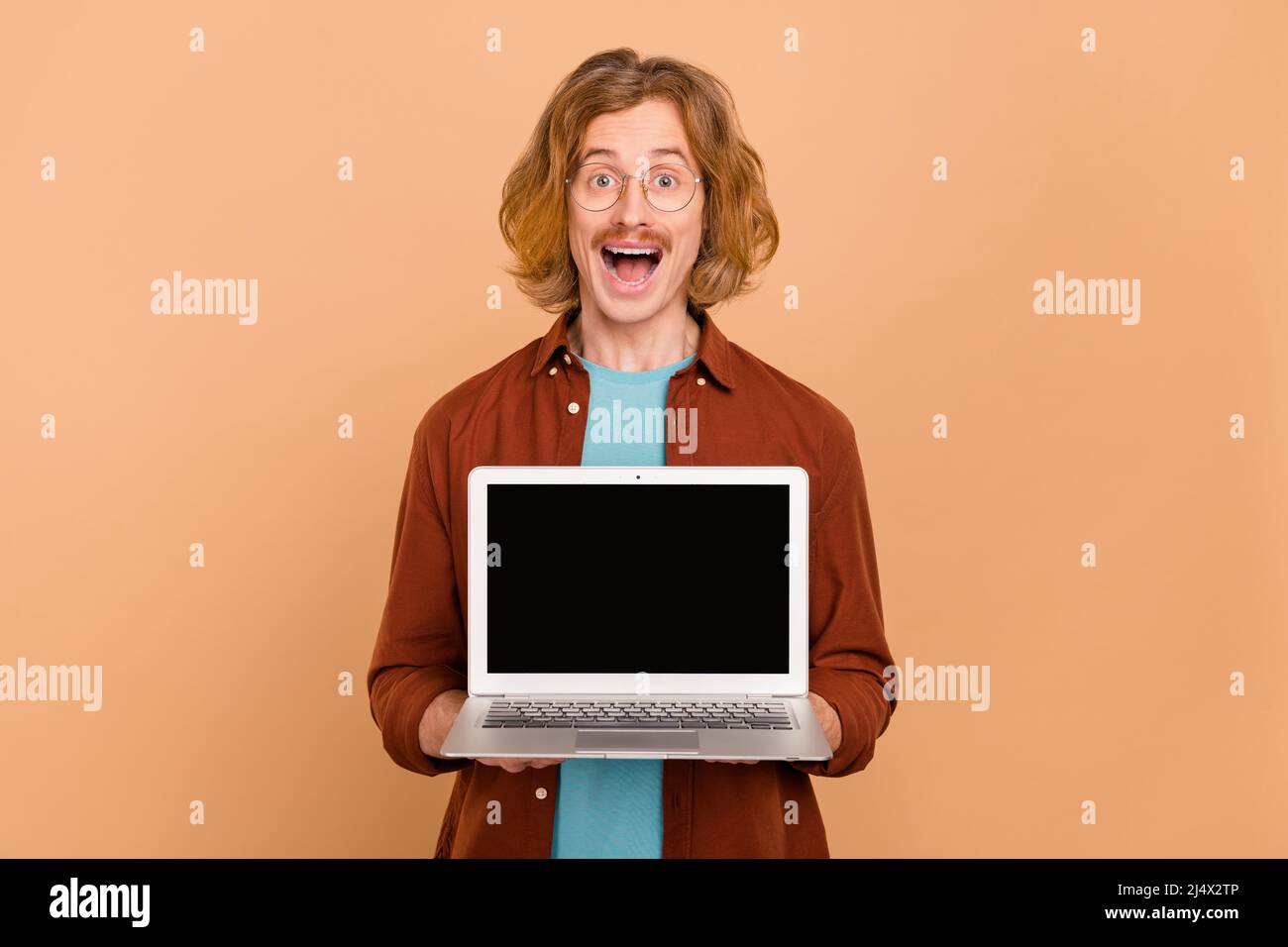 Portrait of handsome cheery trendy red-haired guy holding laptop copy ...