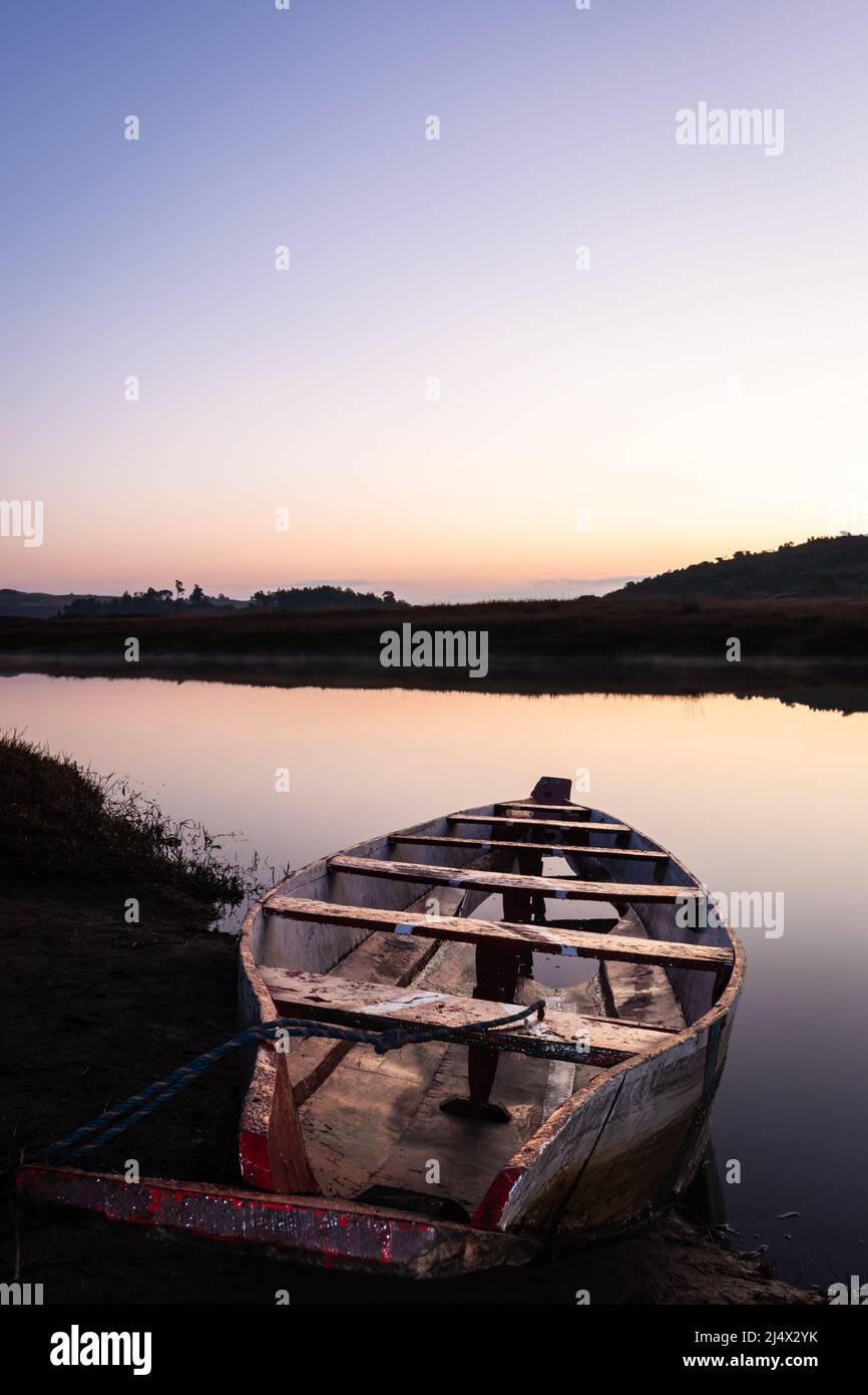 traditional wood boat at calm lake with dramatic sunrise colorful sky ...