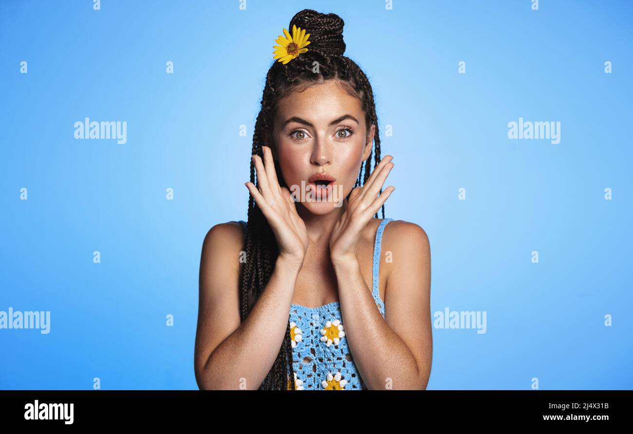 Portrait of beautiful woman with flower in her hair, express surprise ...