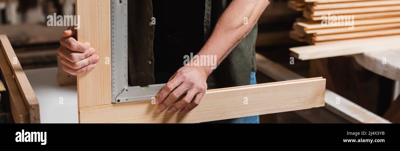 partial view of furniture designer measuring wooden details with corner ...