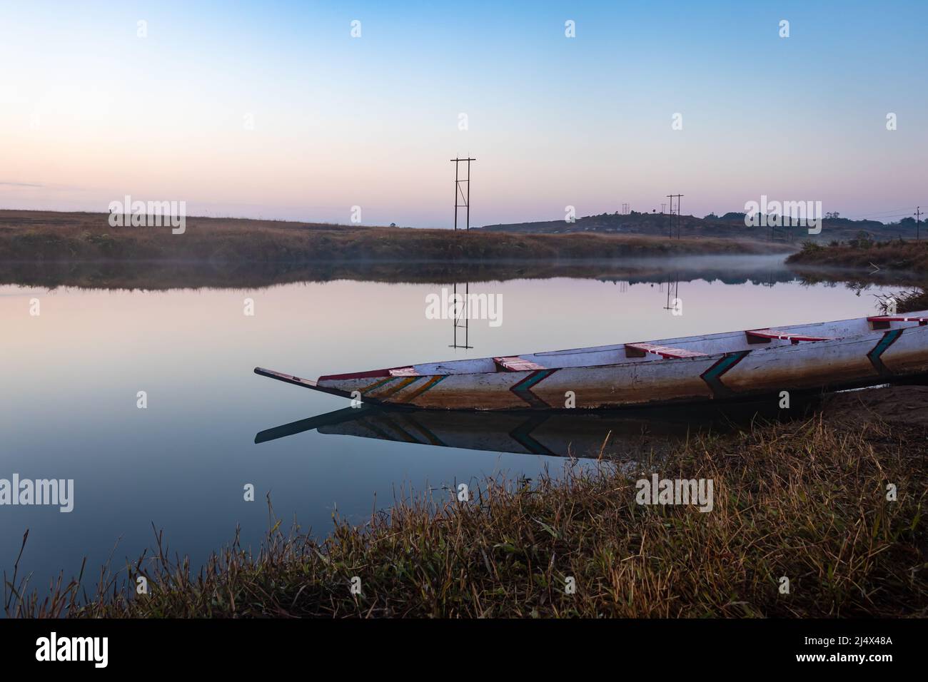 traditional wood boat at calm lake with dramatic sunrise colorful sky ...