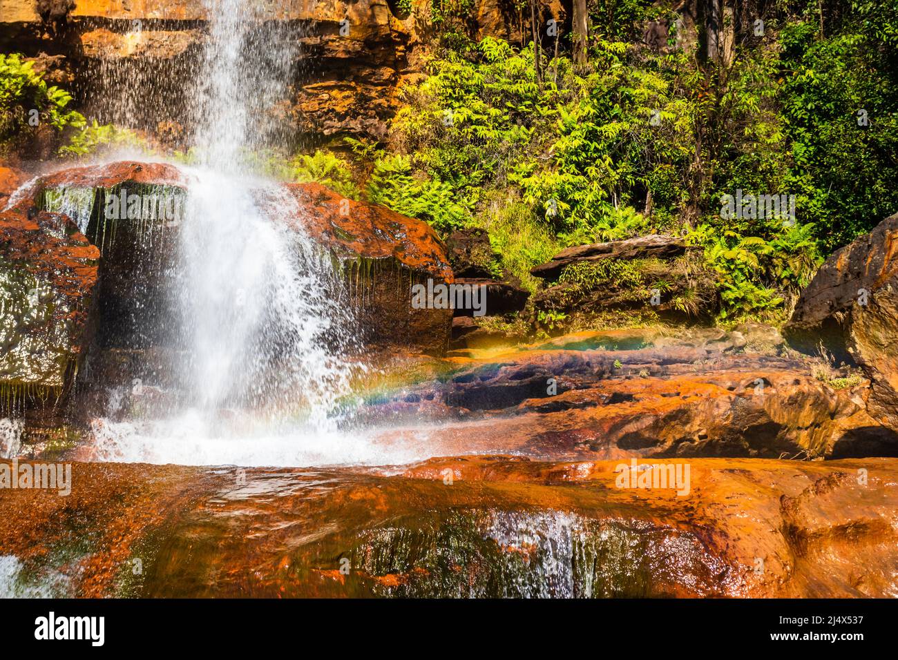 waterfall white streams falling from mountain top at yellow rocks with ...