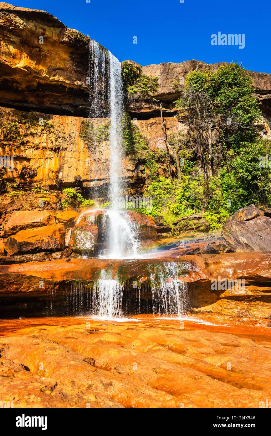 waterfall white streams falling from mountain top at yellow rocks with ...