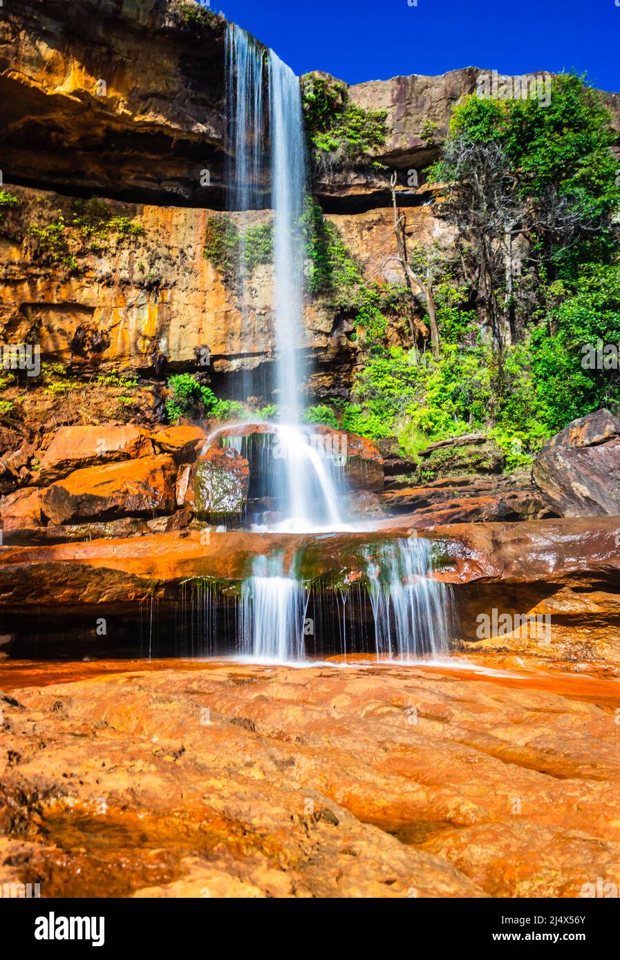 waterfall white streams falling from mountain top at yellow rocks with ...