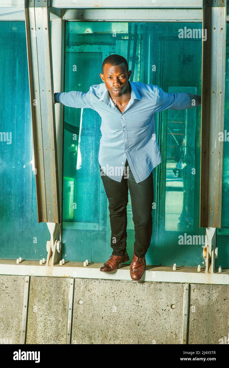 I want to fly. A young black guy standing on metal structures ...