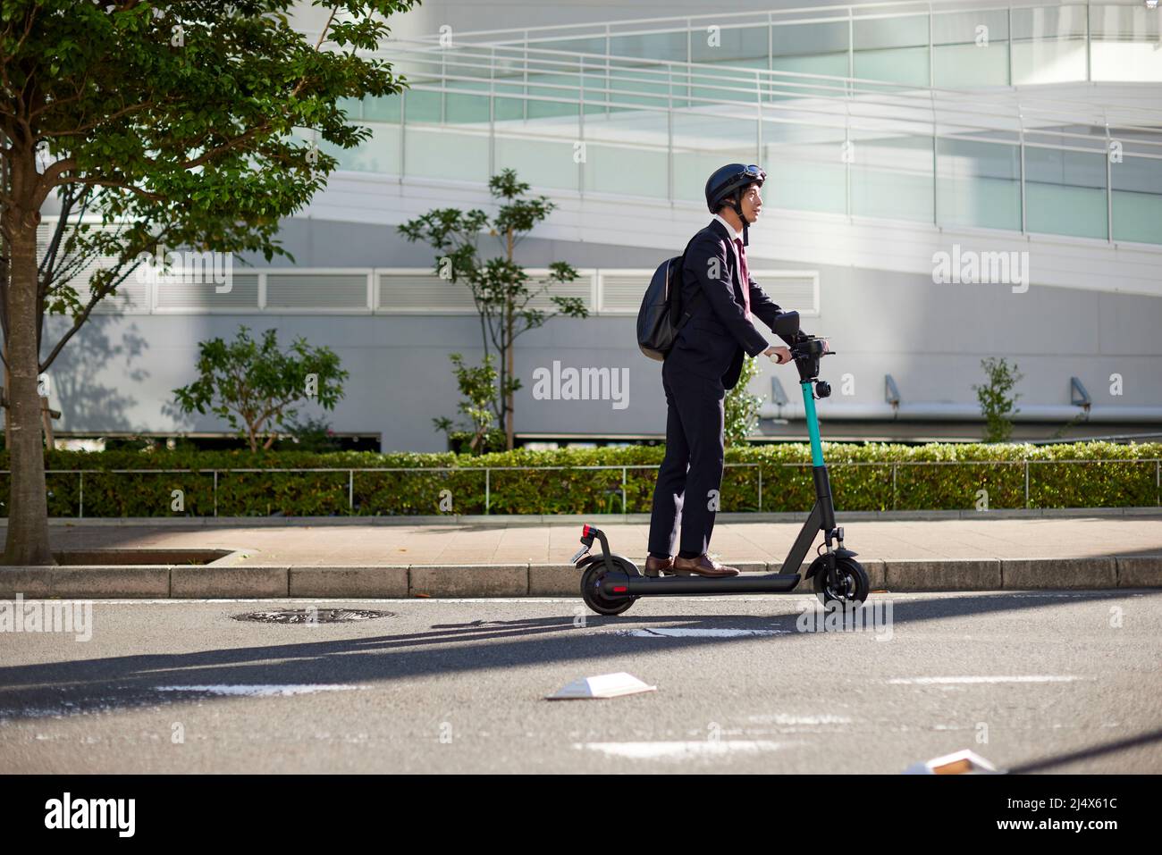 Asian business riding electric scooter hi-res stock photography and images - Alamy