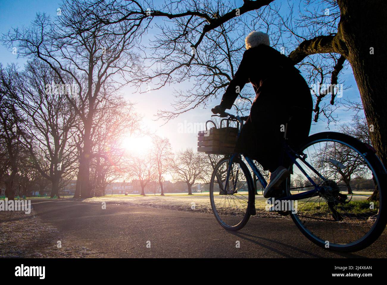 A female cyclist rides her bicycle in the early morning frost as the ...