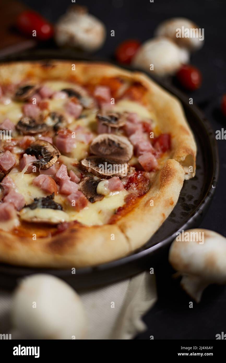 Traditional italian pizza with ham and mushrooms served on plate Stock ...