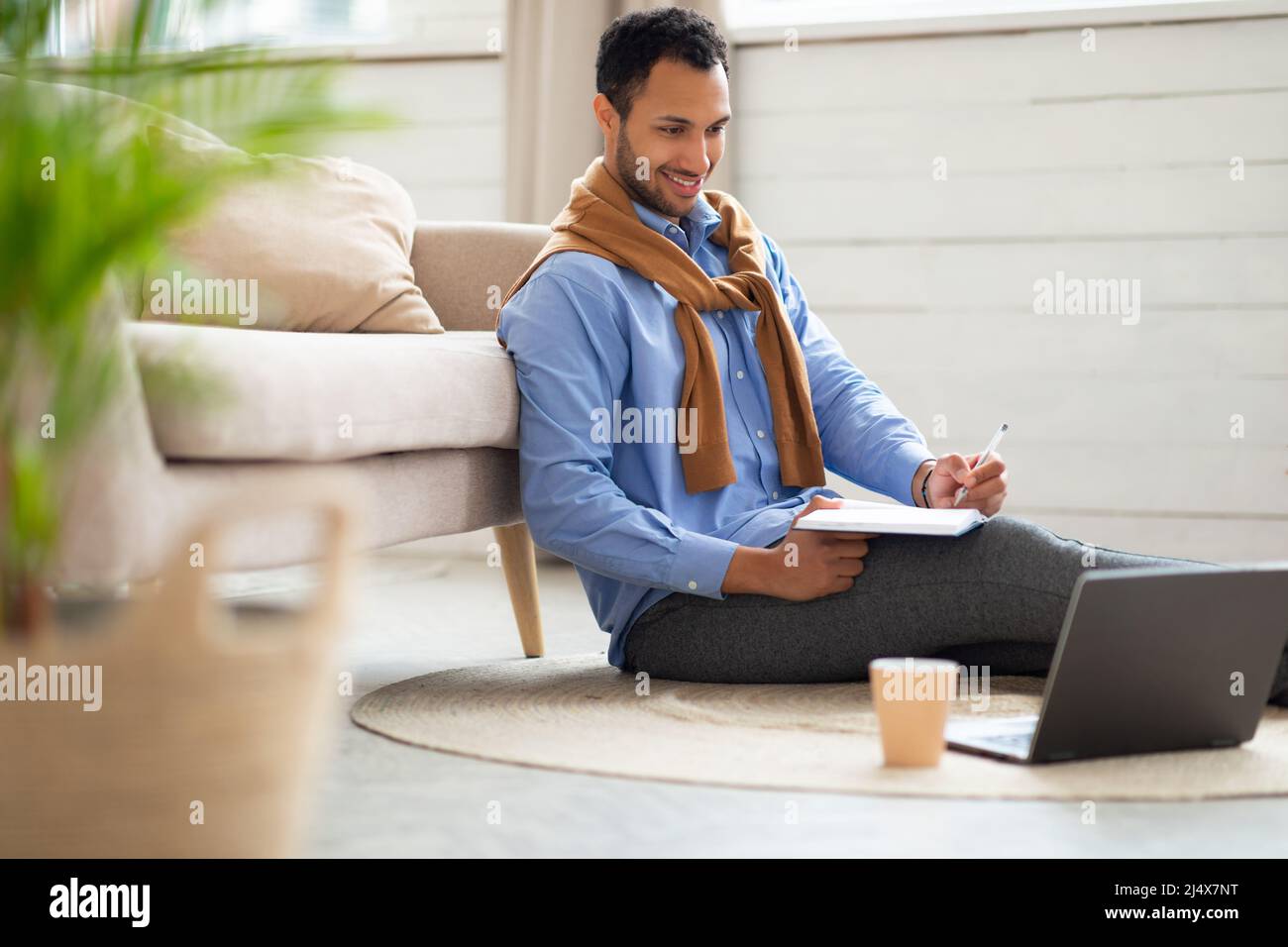 Portrait of smiling Arab man using laptop and writing Stock Photo - Alamy