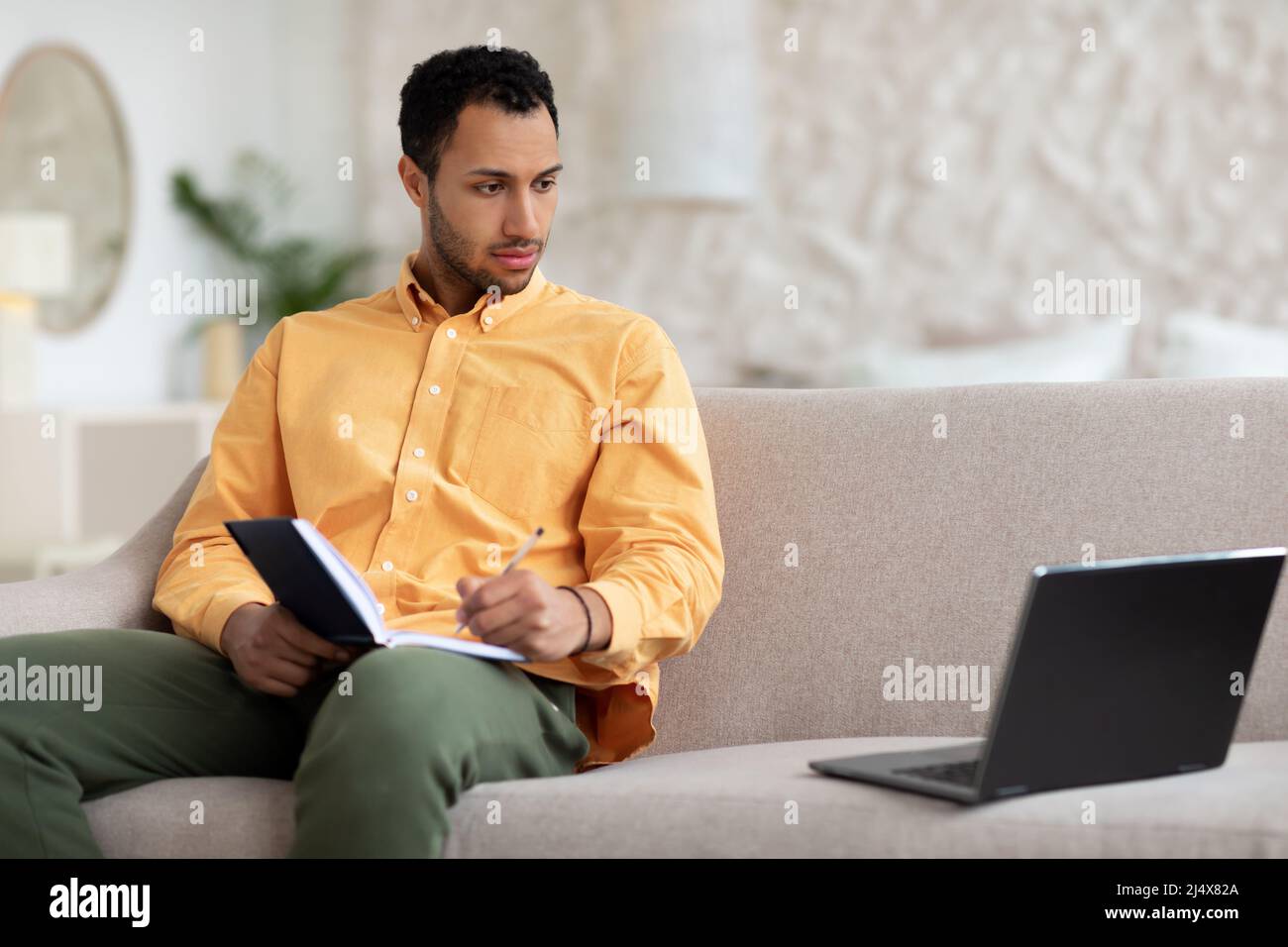Portrait of focused Arab man using laptop and writing Stock Photo - Alamy