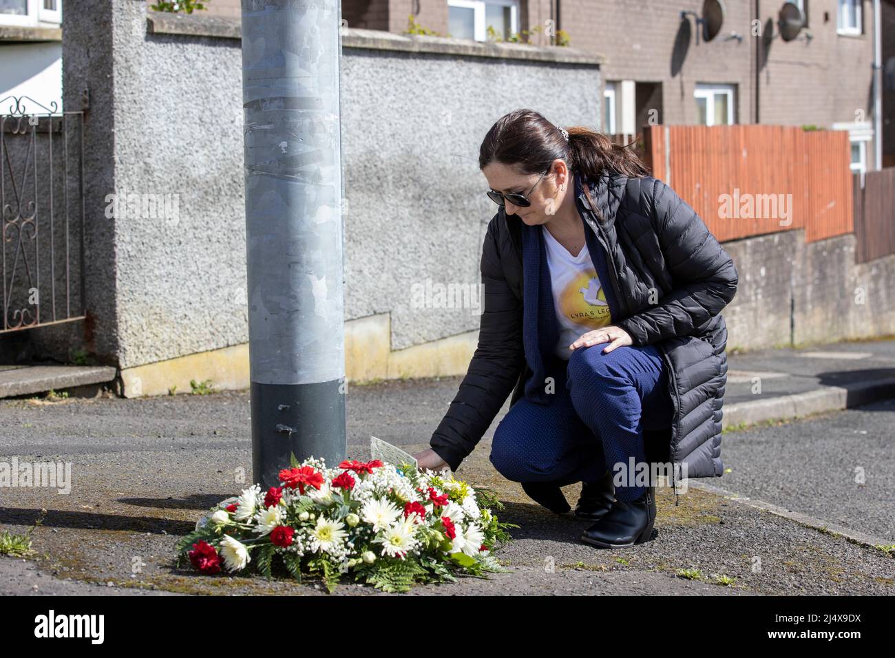 Lyra McKee's sister Joan Hunter arranges wreaths at the location where ...