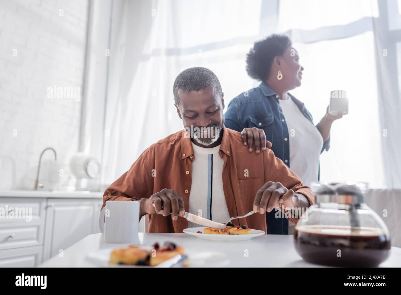 senior african american man having breakfast near happy wife Stock ...