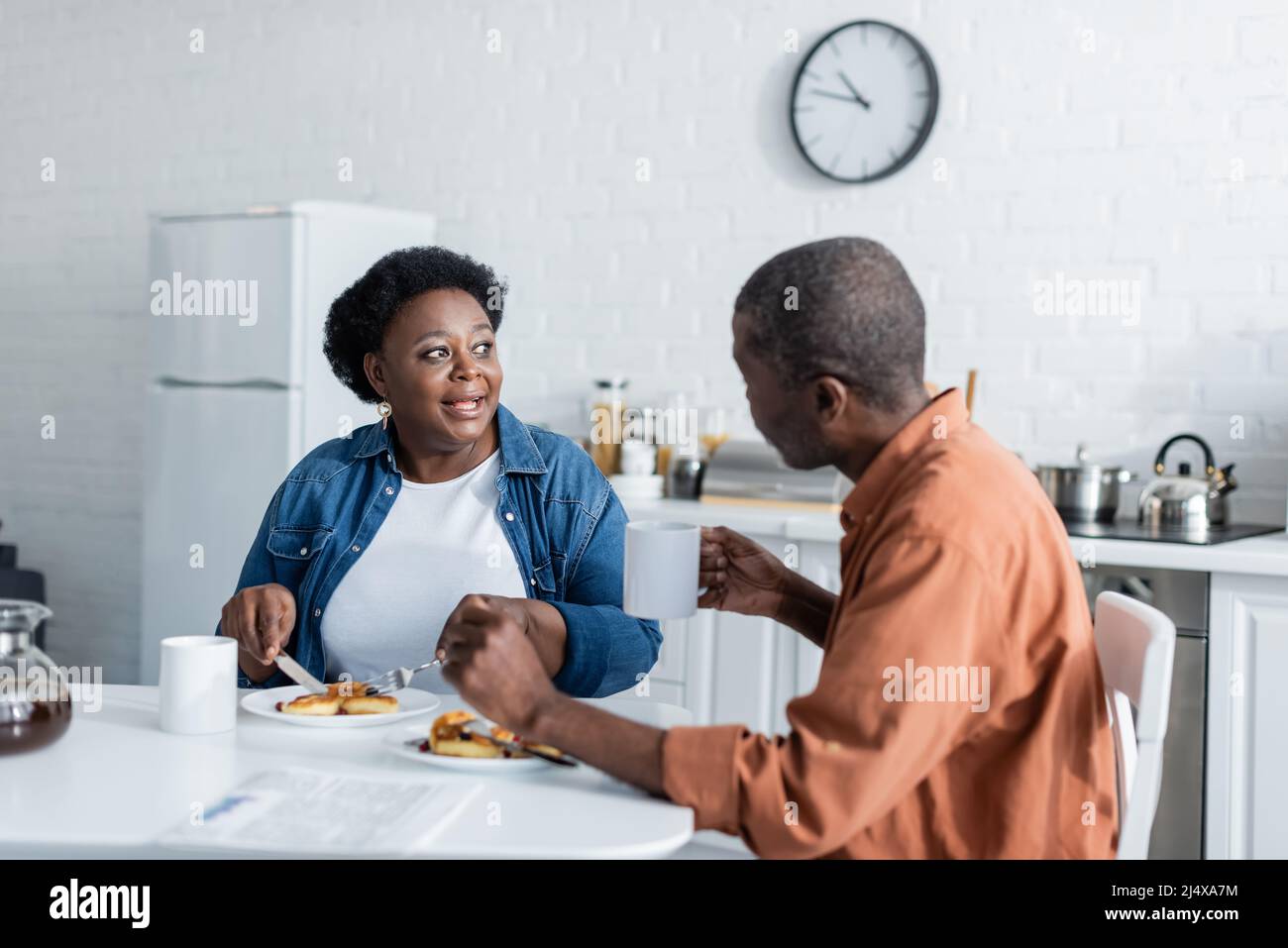 senior african american woman talking with husband during breakfast at ...