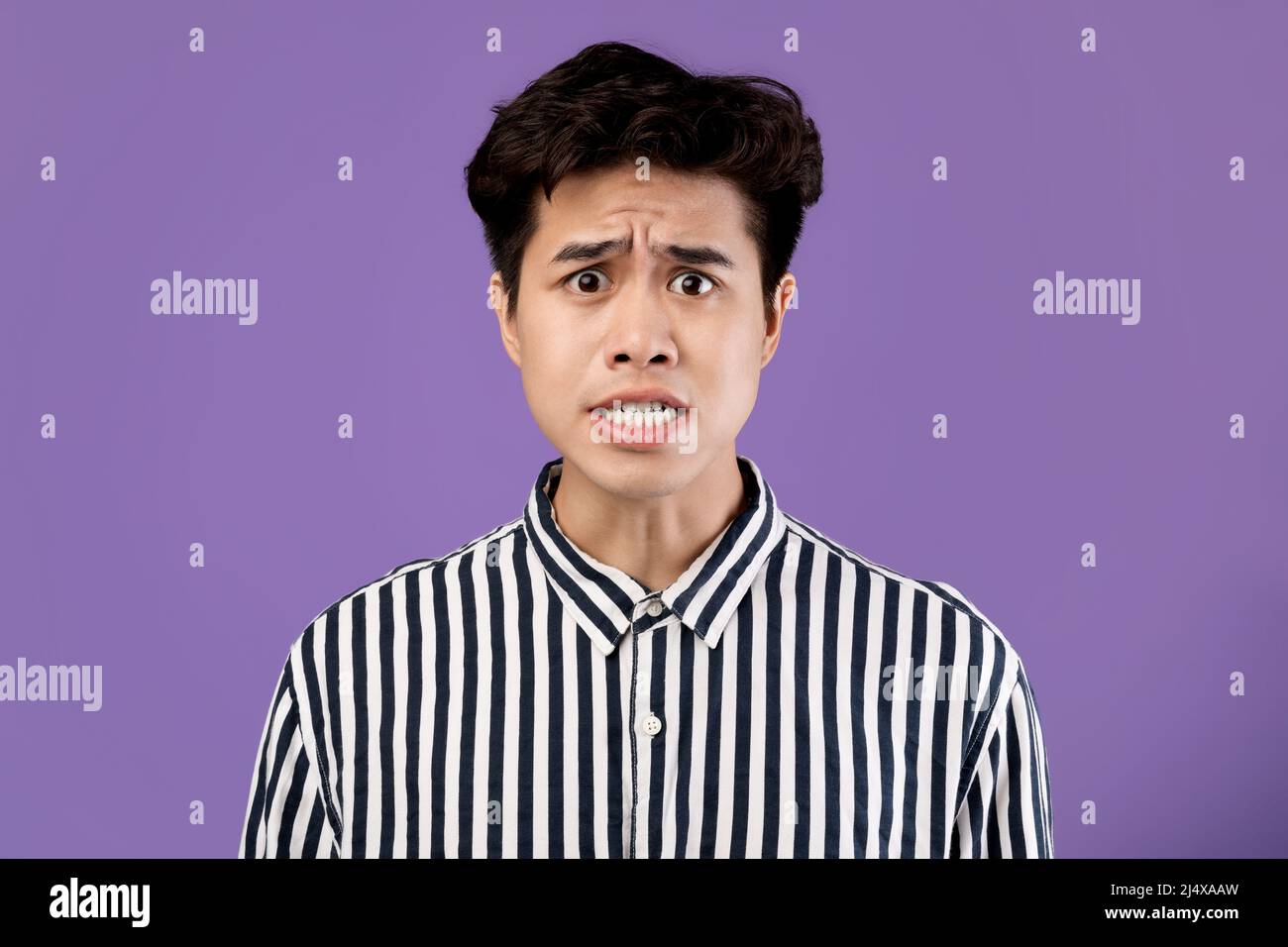 Surprised Asian man staring at camera at studio Stock Photo - Alamy