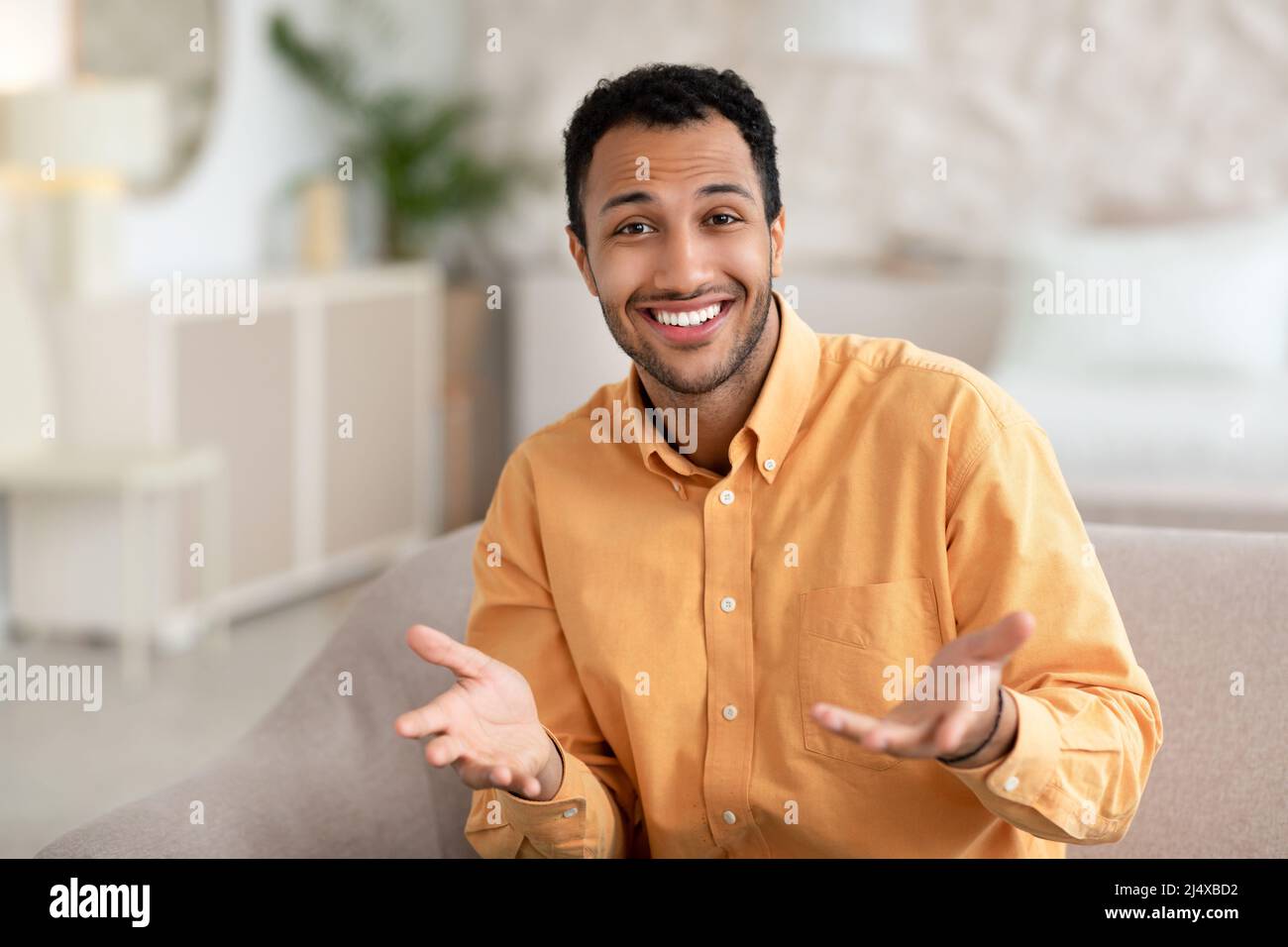 Smiling young man talking and gesturing to camera Stock Photo - Alamy