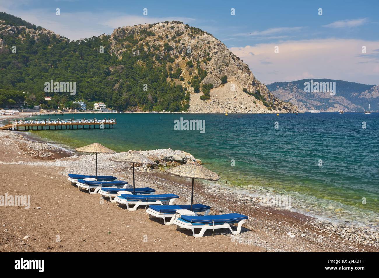 sandy beach without people and with sun loungers, umbrellas, palm trees ...