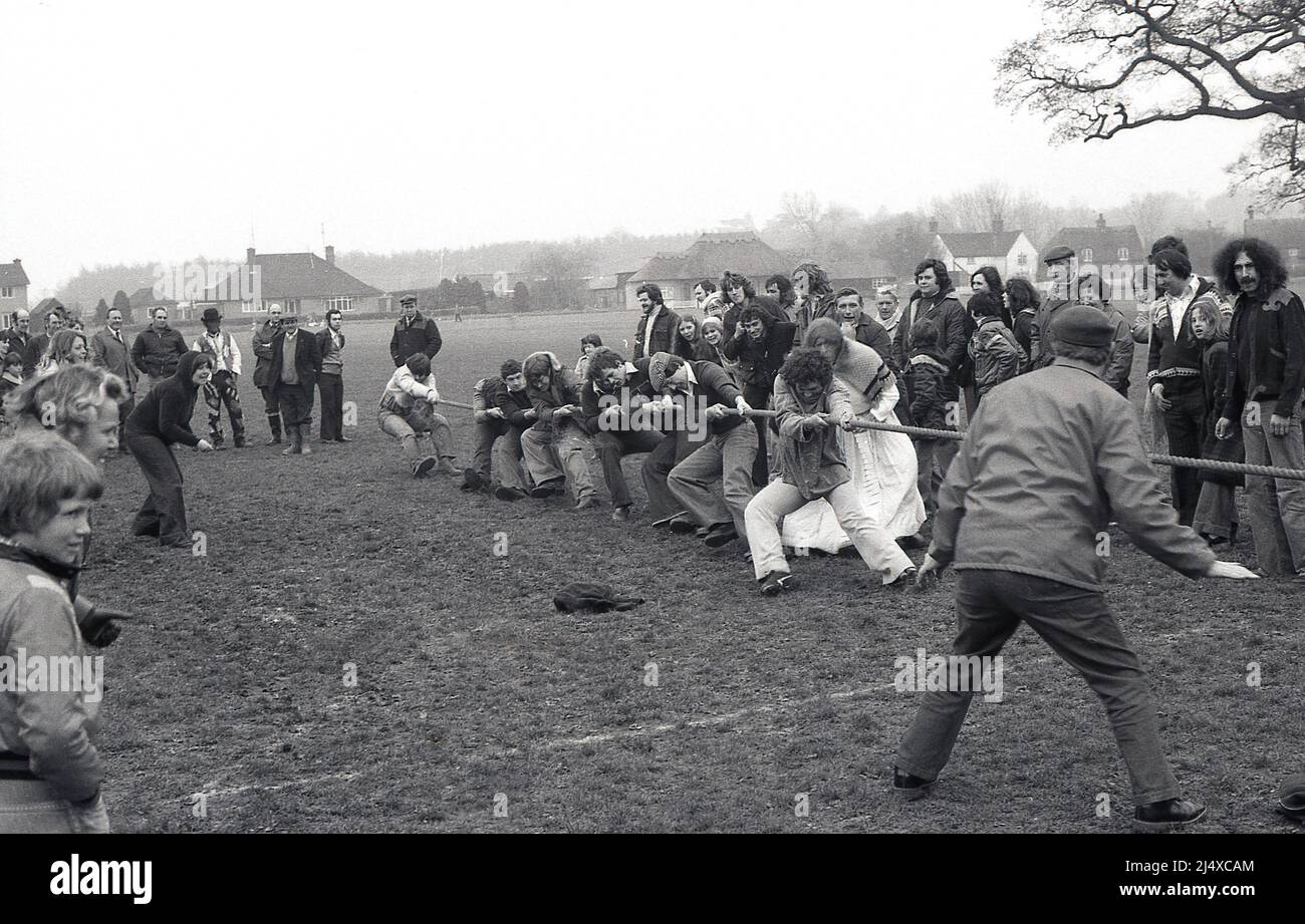 1980s, histrocial, spectators watching local men taking part in a tug ...