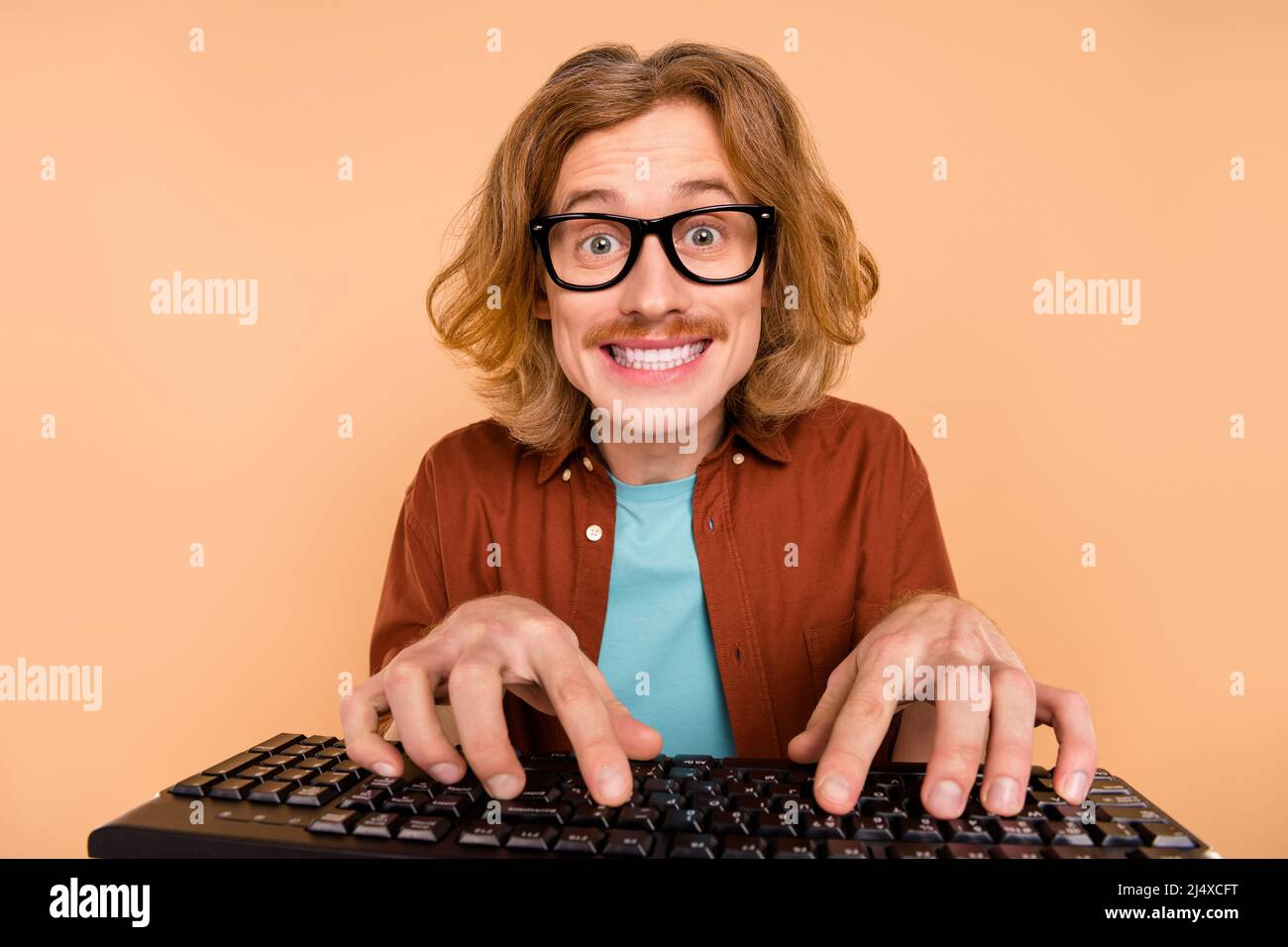 Portrait of handsome trendy cheery red-haired guy writing html tech ...